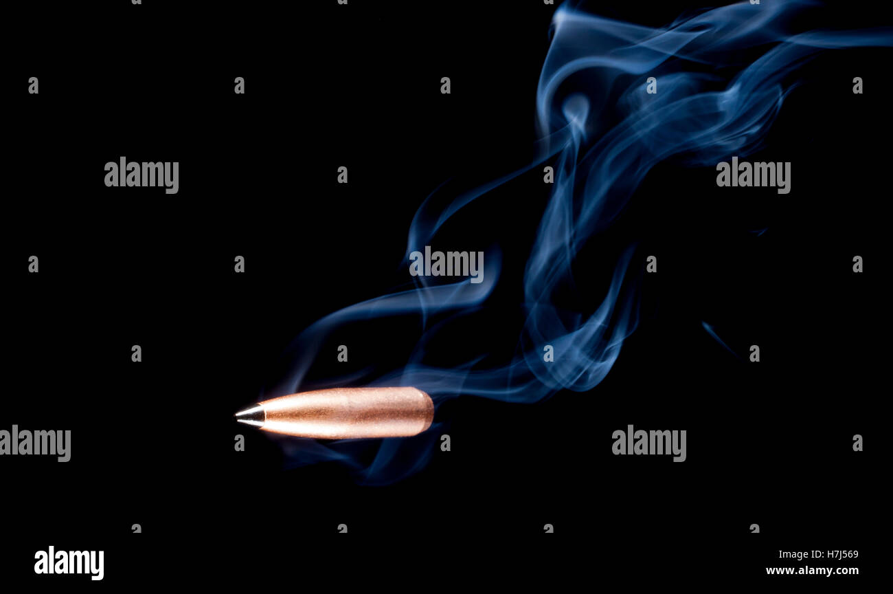 Smoke rising from a copper plated bullet with a black polymer tip Stock ...