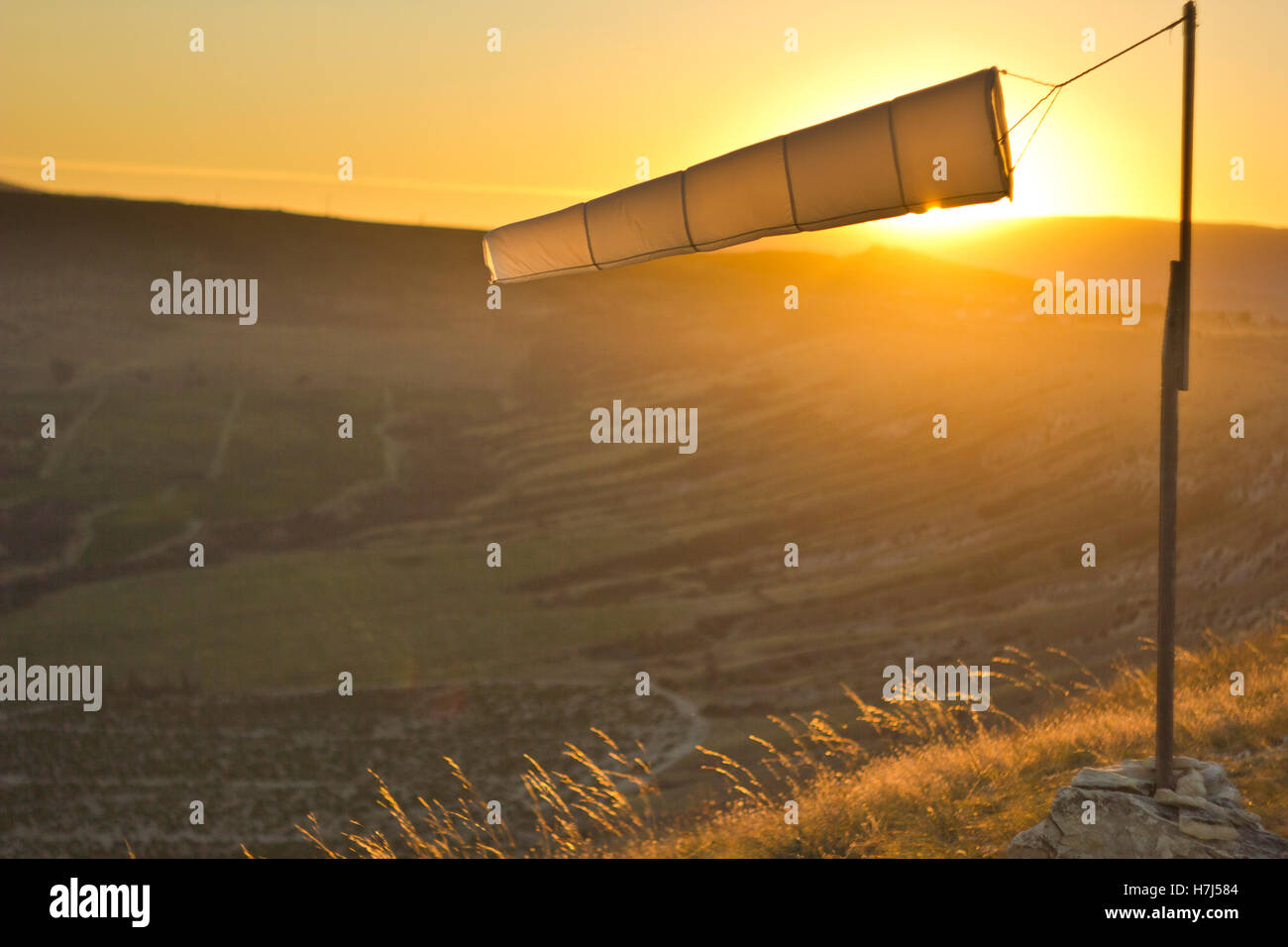 paraglider white windsock at sunset in mountains against sun Stock ...