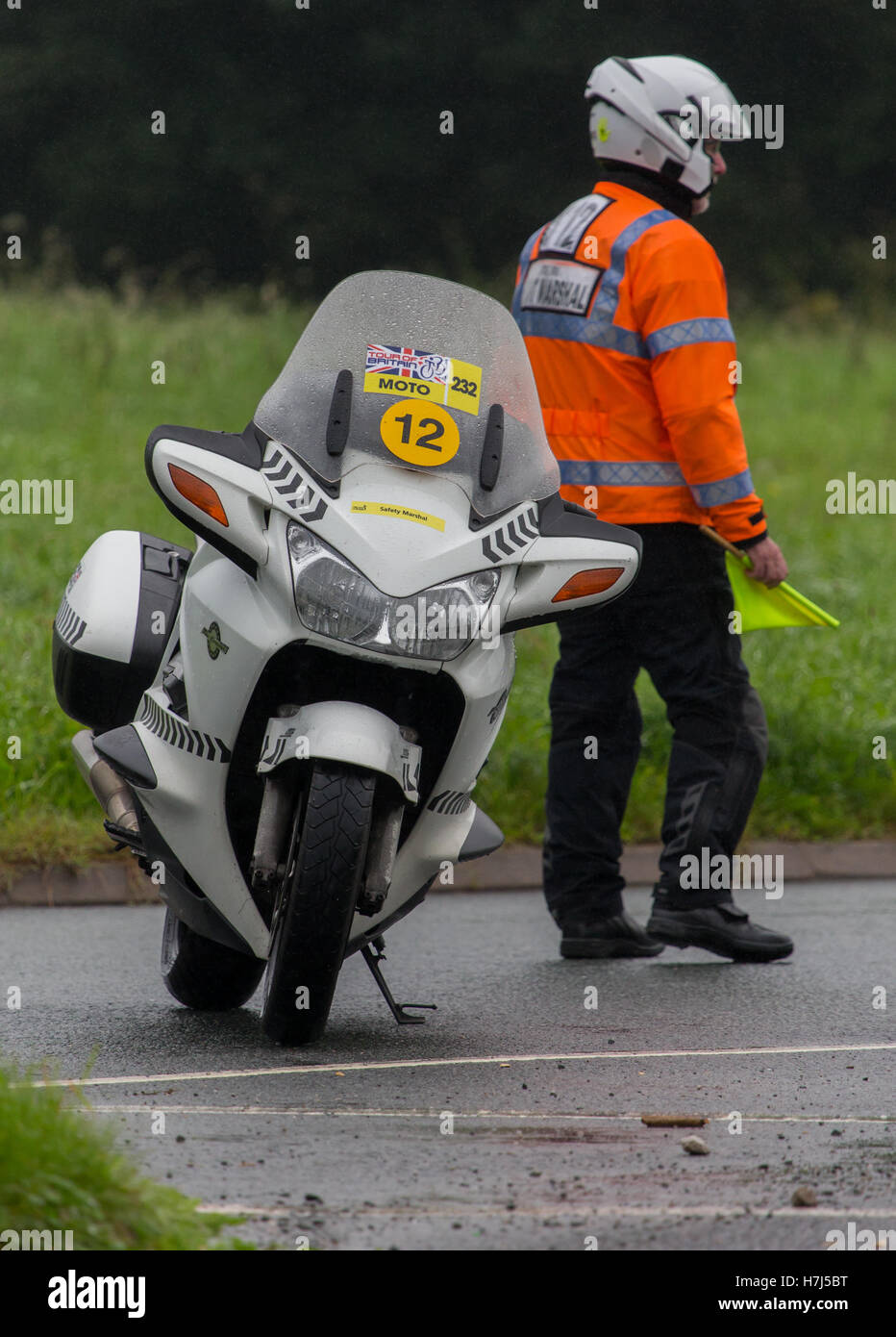 A race marshal waiting to guide cyclists competing in the Tour of ...