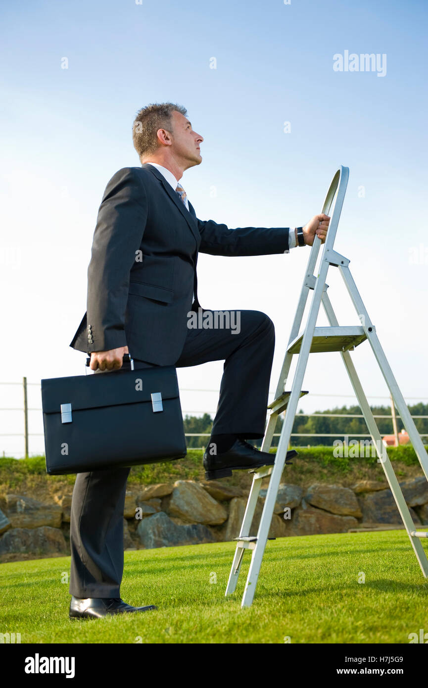 Businessman climbing a ladder, symbolic image for the career ladder ...