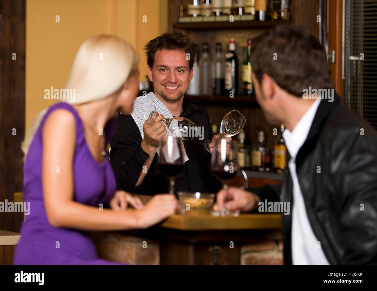 Couple and waiter at the bar Stock Photo - Alamy