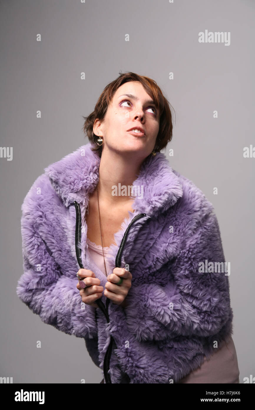 Young woman posing in studio wearing lila fur Stock Photo - Alamy
