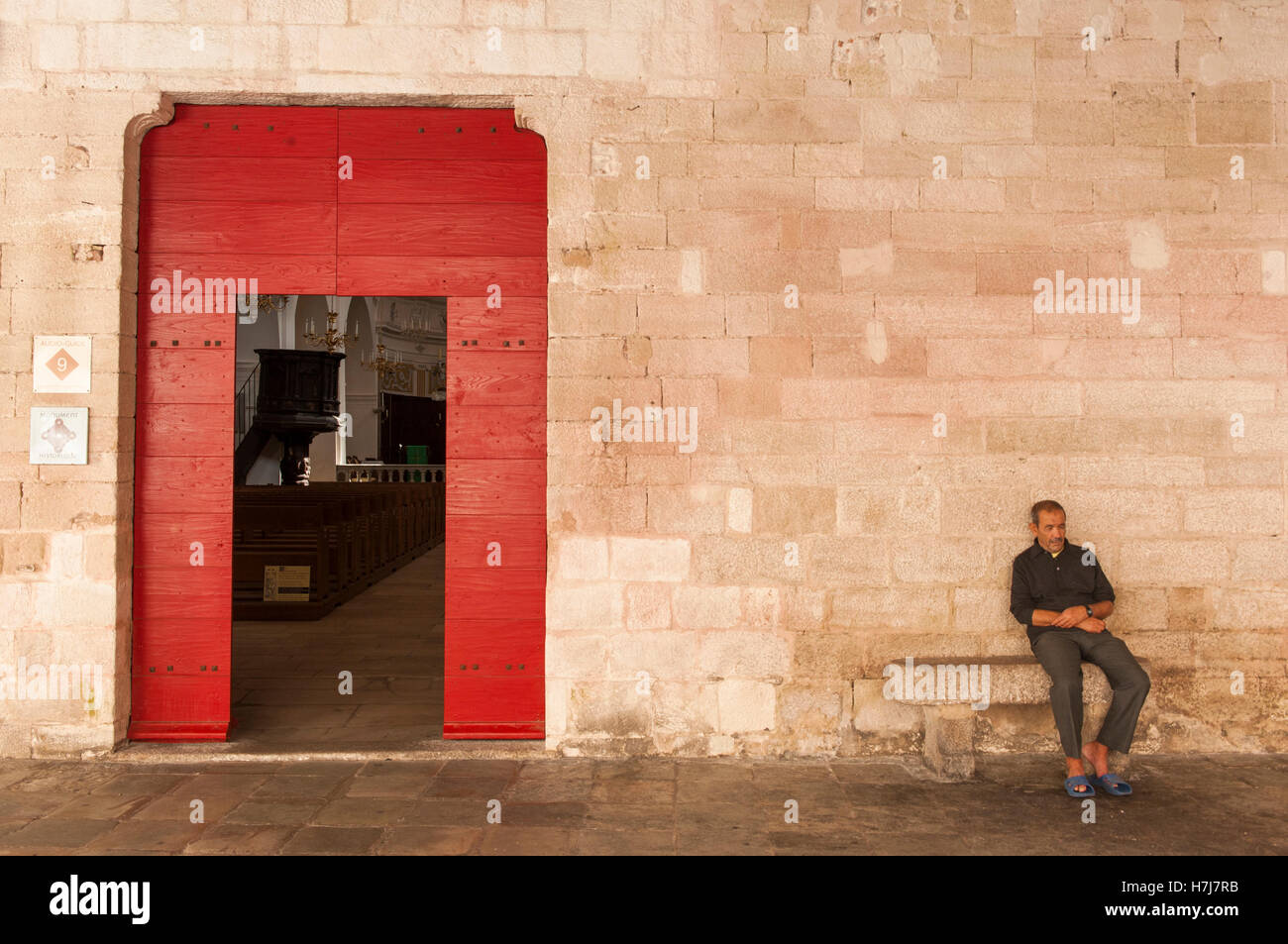 Corsican man setting next to the entrance of the church Église Sainte ...