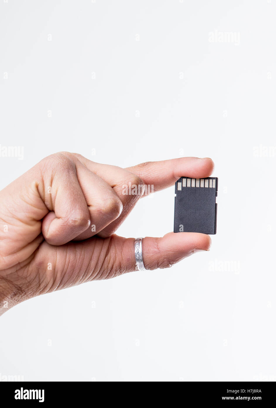 Close up on single hand holding dark colored blank SD card over ...