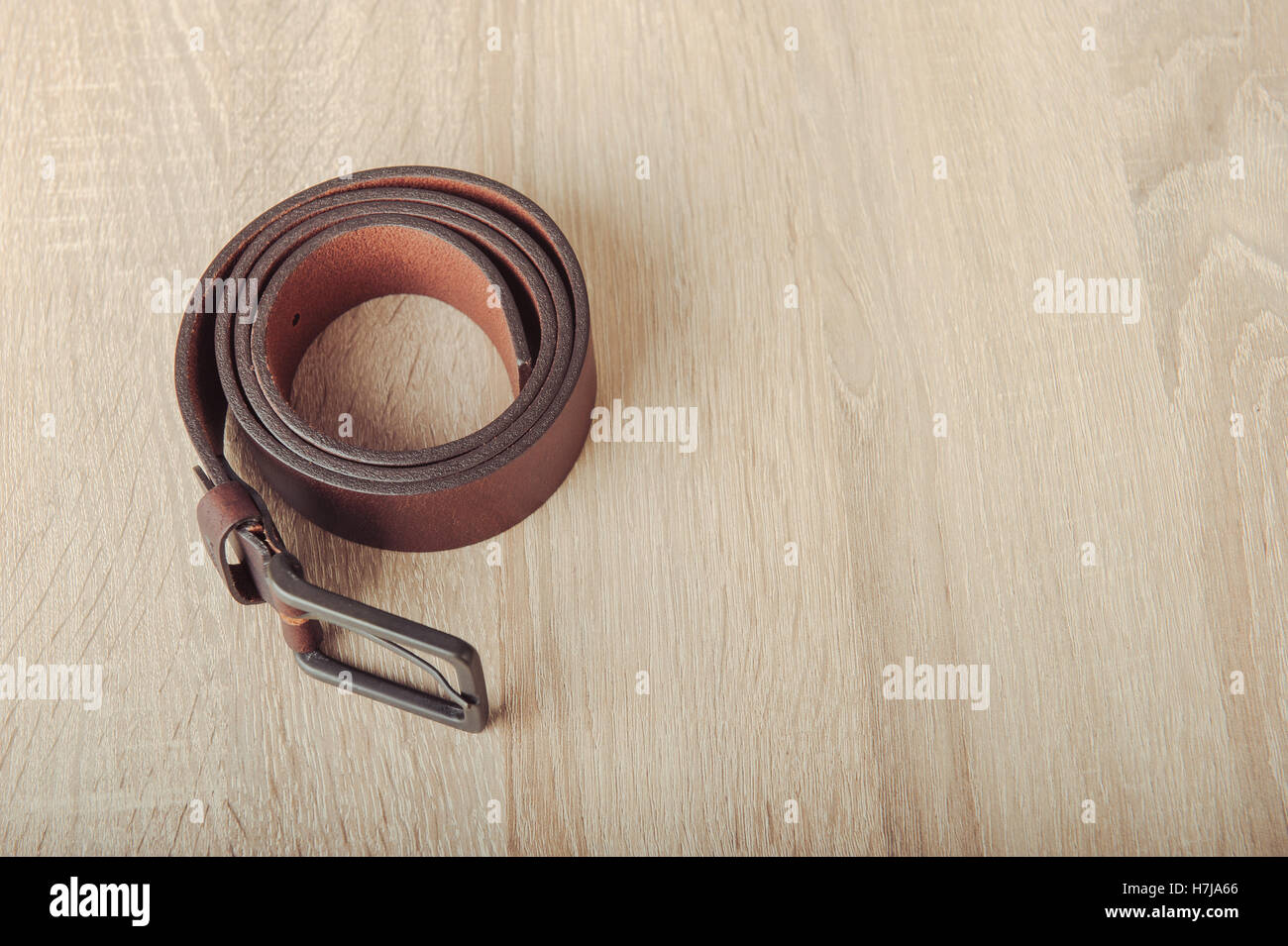 Leather belt on the wooden desk table Stock Photo - Alamy