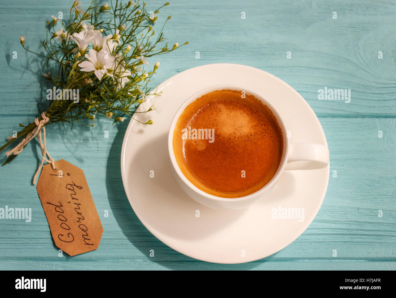 Coffee mug with white flowers and notes good morning on blue rustic ...