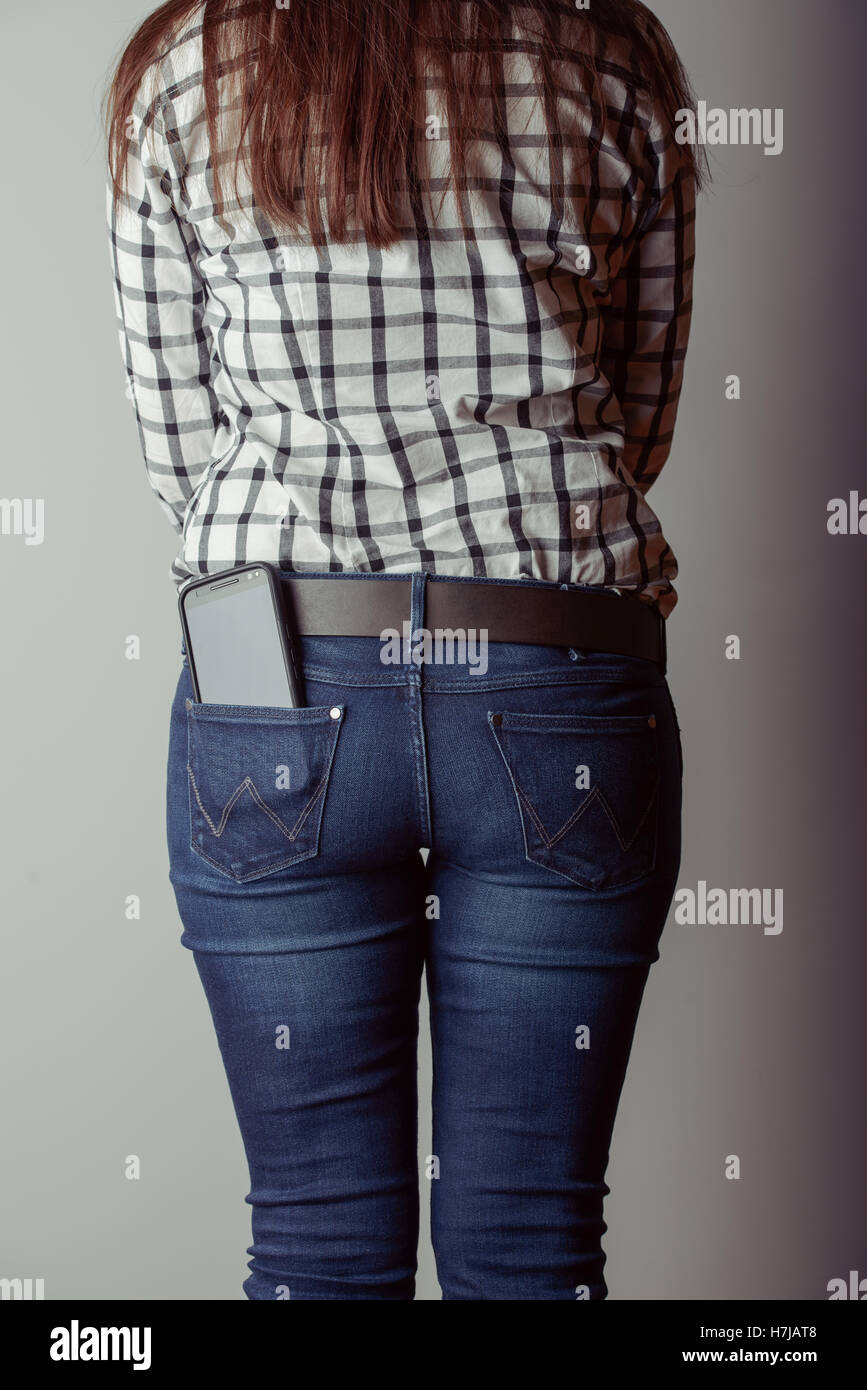 Woman takes out smartphone of her rear pocket of jeans Stock Photo - Alamy