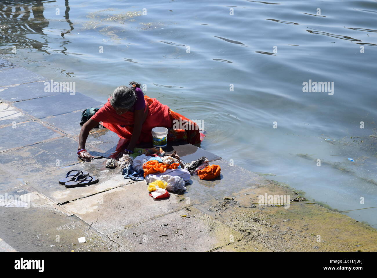 Indian woman washing her clothes in the water of lake Pichola in ...