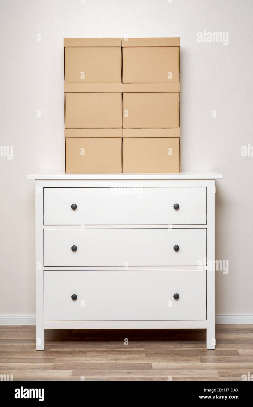 Cardboard boxes on white wooden commode Stock Photo - Alamy
