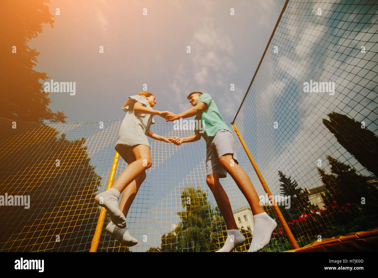 Couple jumping on trampoline in the park Stock Photo - Alamy