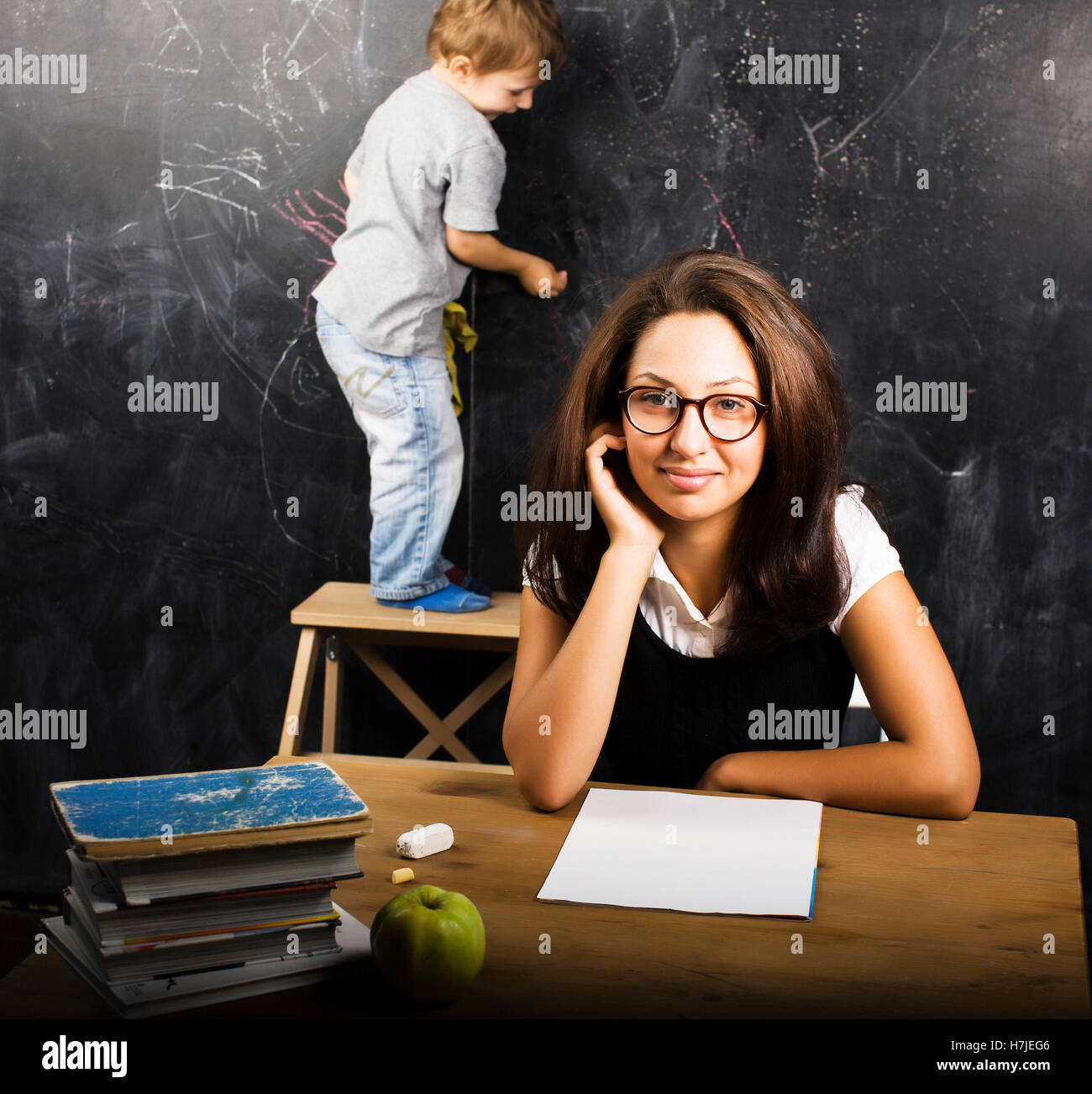 little cute boy with young teacher in classroom studying at blac Stock ...