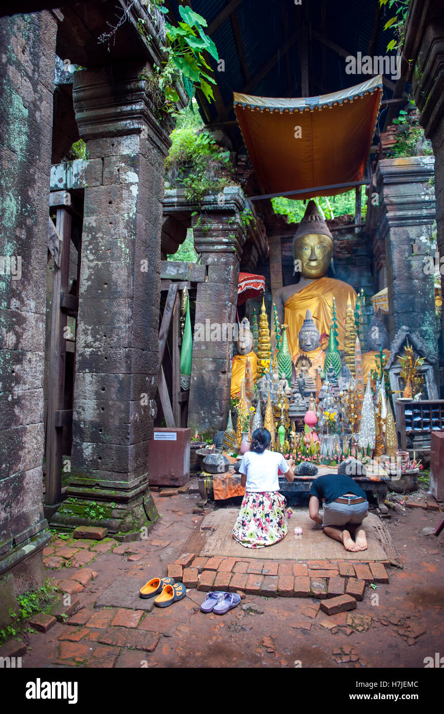Buddhist devotees pray at Wat Phu, an ancient ruined Khmer Hindu temple ...