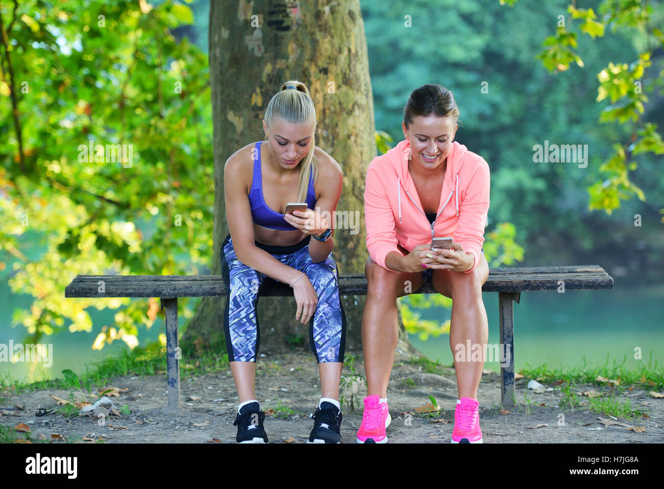 Shot of two females taking a quick break while out for a trail run ...