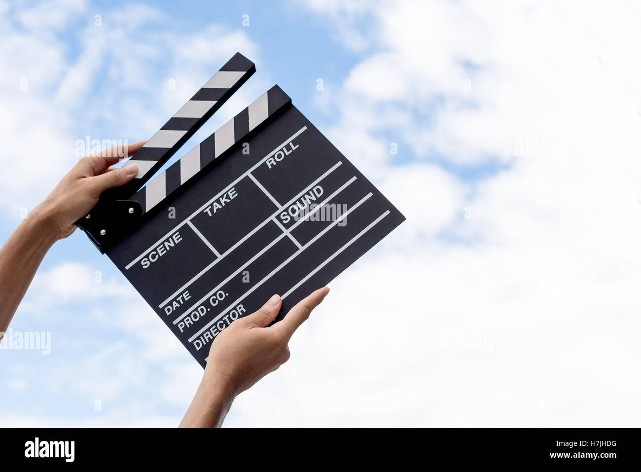 Hands holding clapper board on sky Stock Photo - Alamy