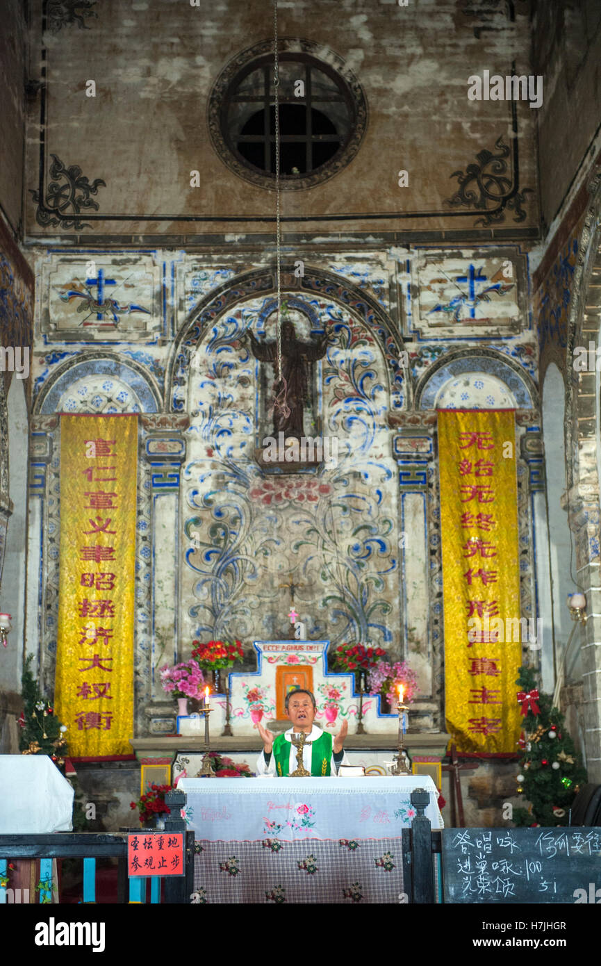 Evening mass in Cizhong church, a stone and stucco church built in 1910 ...