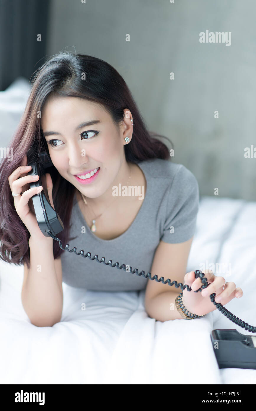 Relaxed young woman on the bed call a phone Stock Photo - Alamy