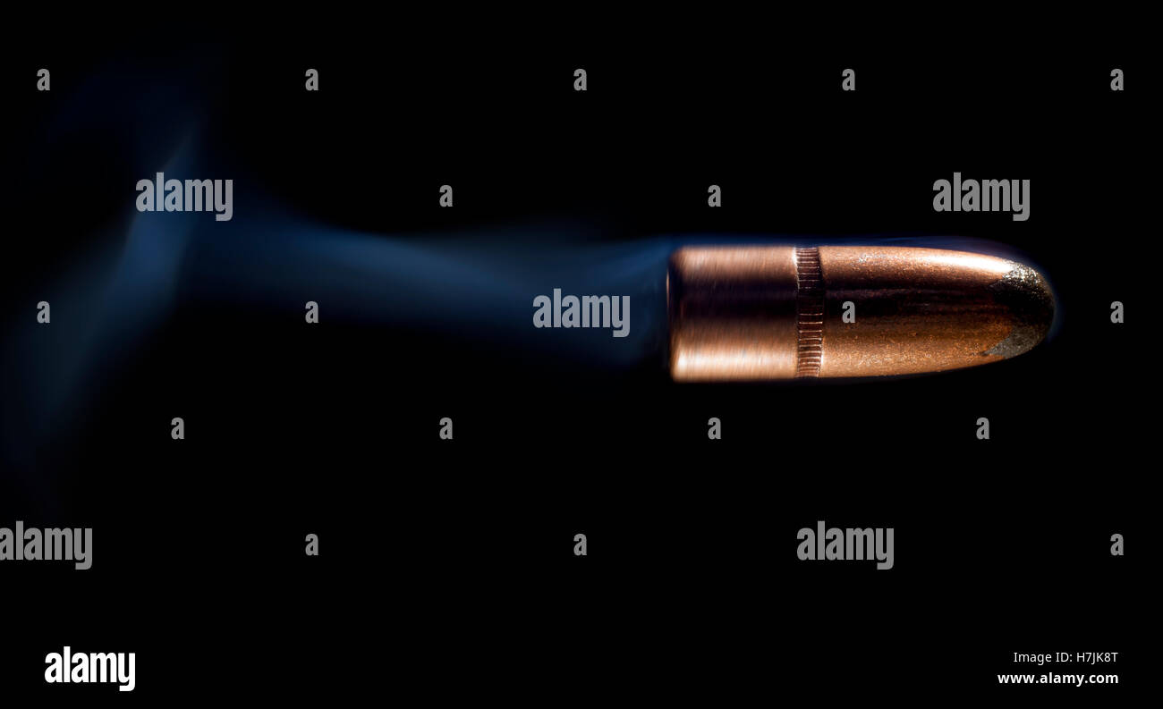 Lead bullet with copper coating on black and smoke behind Stock Photo ...