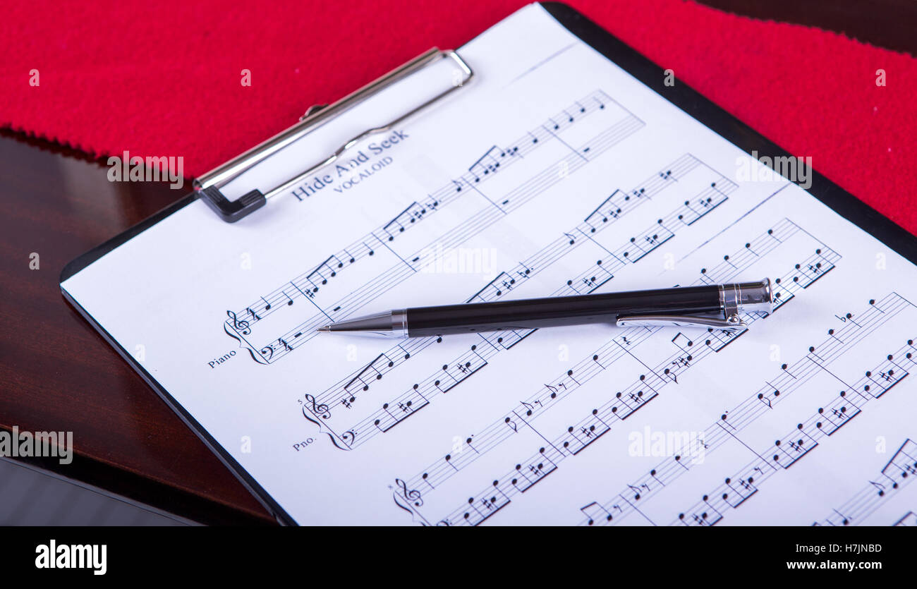 Music nodes and pen ballpen red carpet cloth on the piano table Stock ...