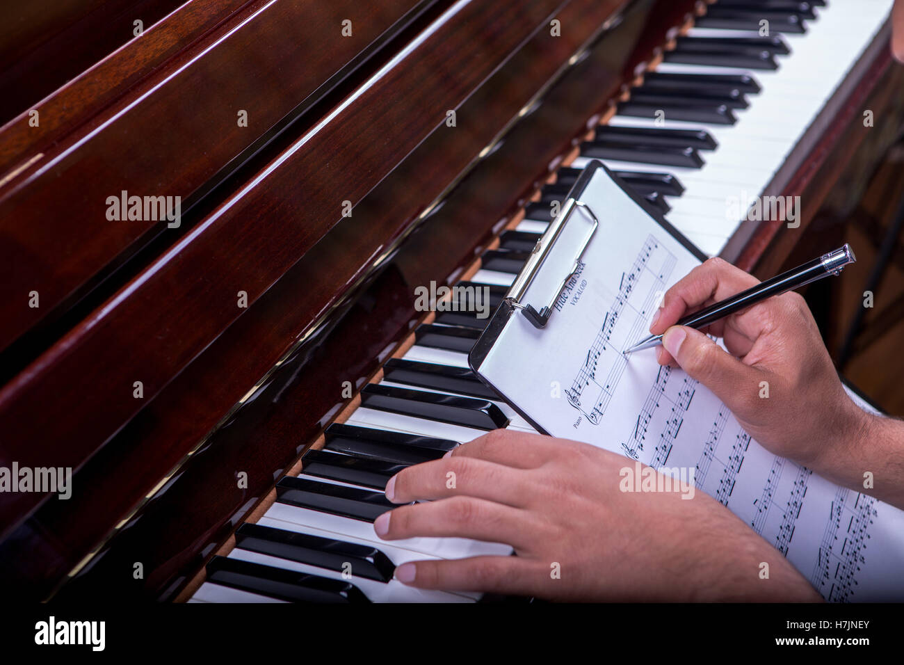Man playing piano tune and taking nodes writing notes with black ...