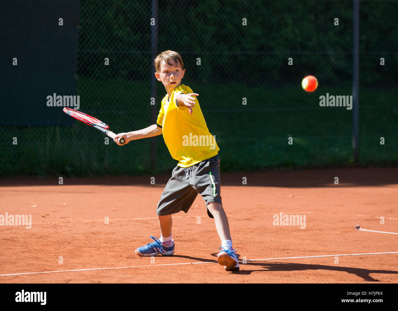 Boy playing tennis at a junior competition Stock Photo - Alamy