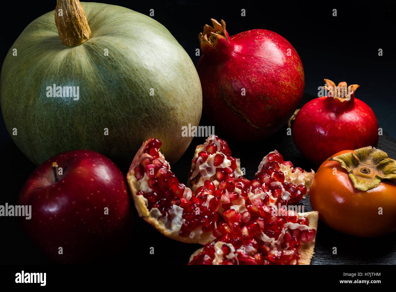 Various fruits of winter on black plate Stock Photo - Alamy