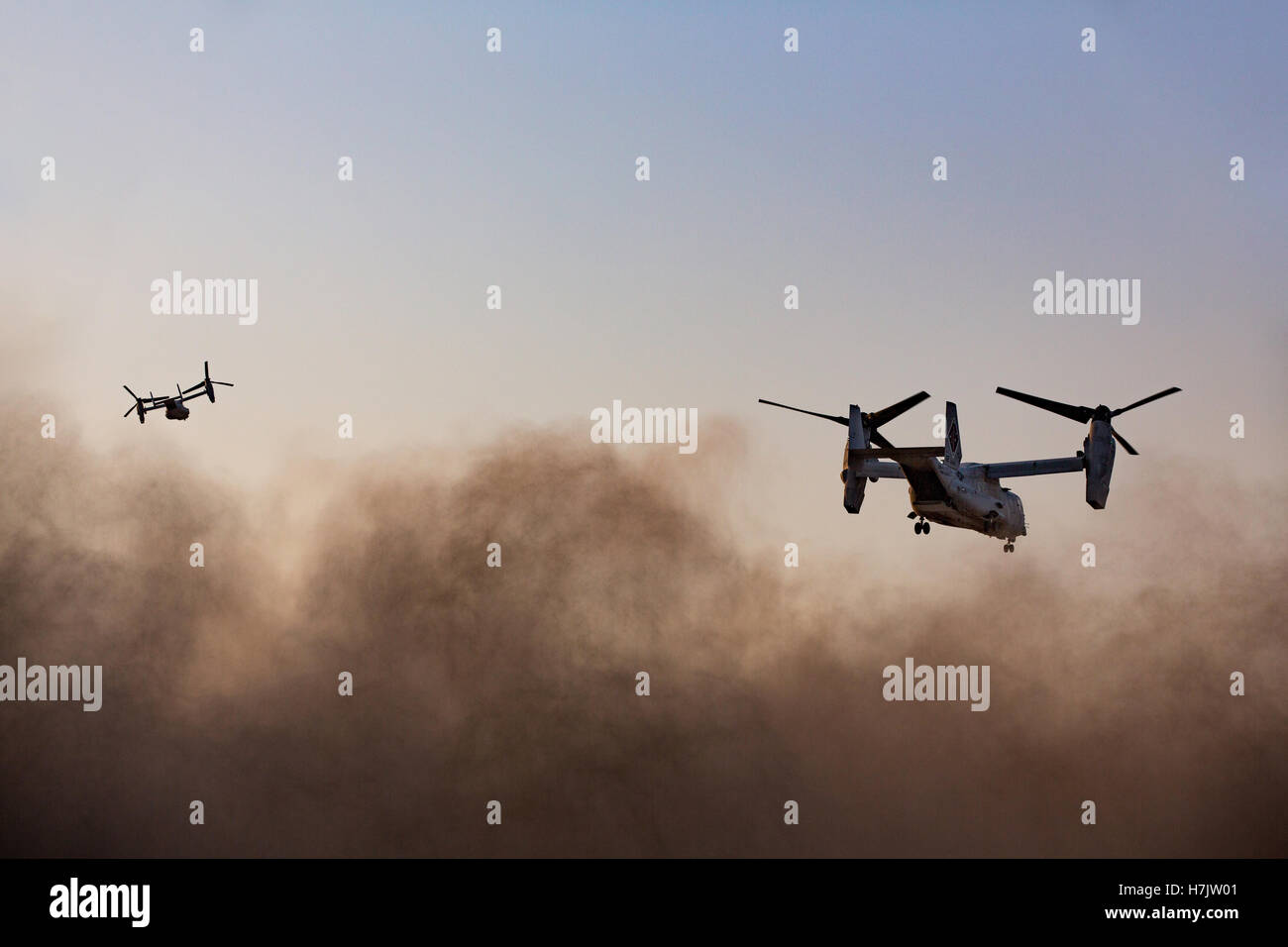 Clouds of dust gather in the air as MV-22B Osprey aircraft take flight ...