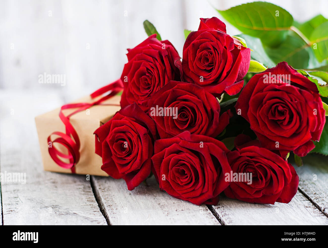 Bouquet of red roses on a light wooden background Stock Photo - Alamy