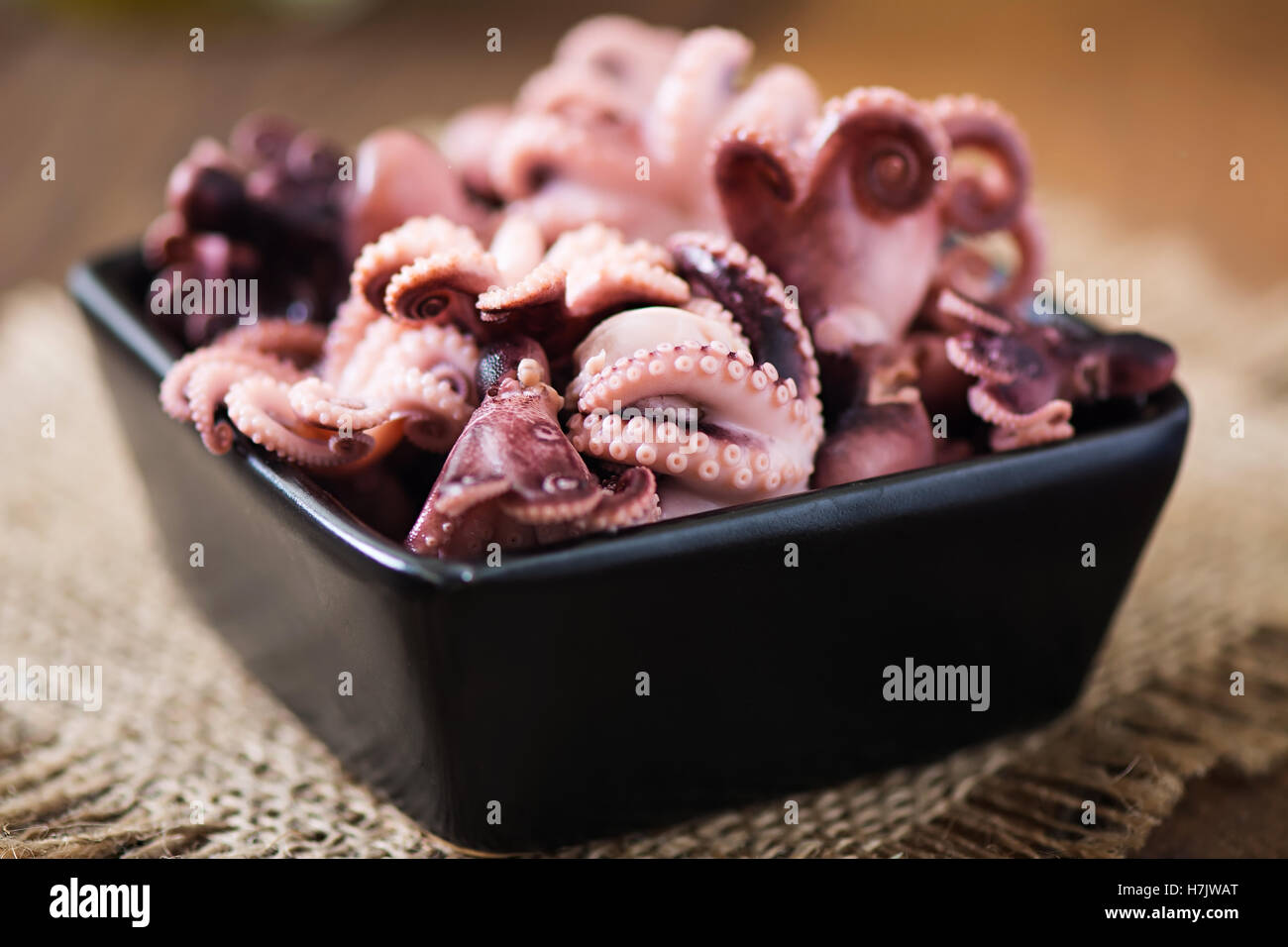 Boiled small octopus on a black plate Stock Photo - Alamy