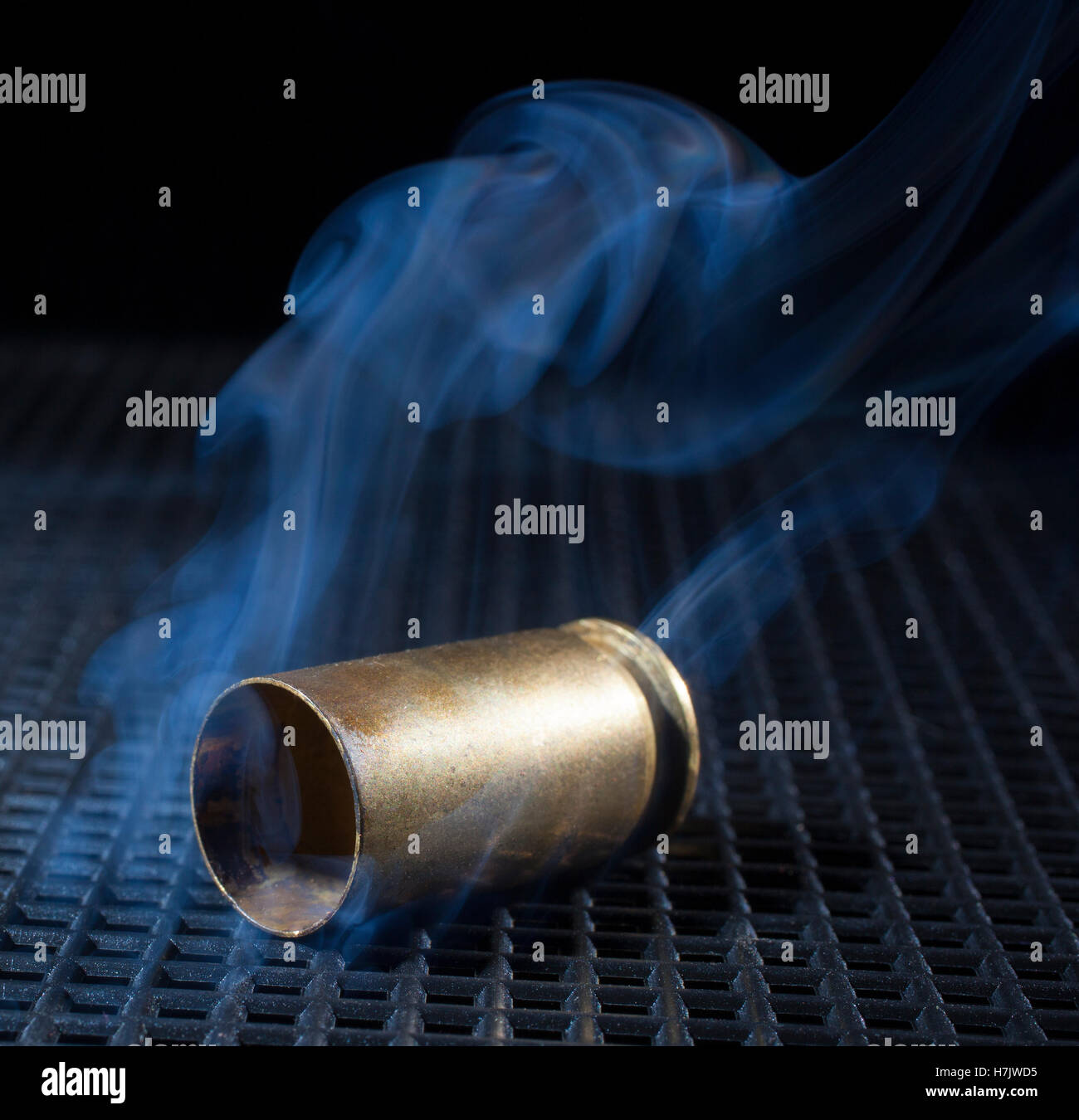 Brass shell that is empty after being shot from a handgun with smoke ...