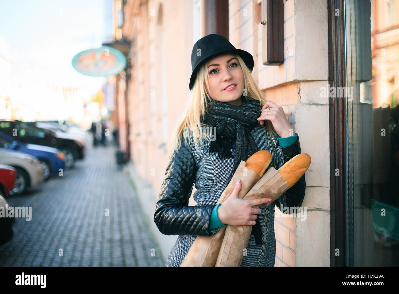 Young beautiful woman with a loaf of bread in her hands in autumn ...