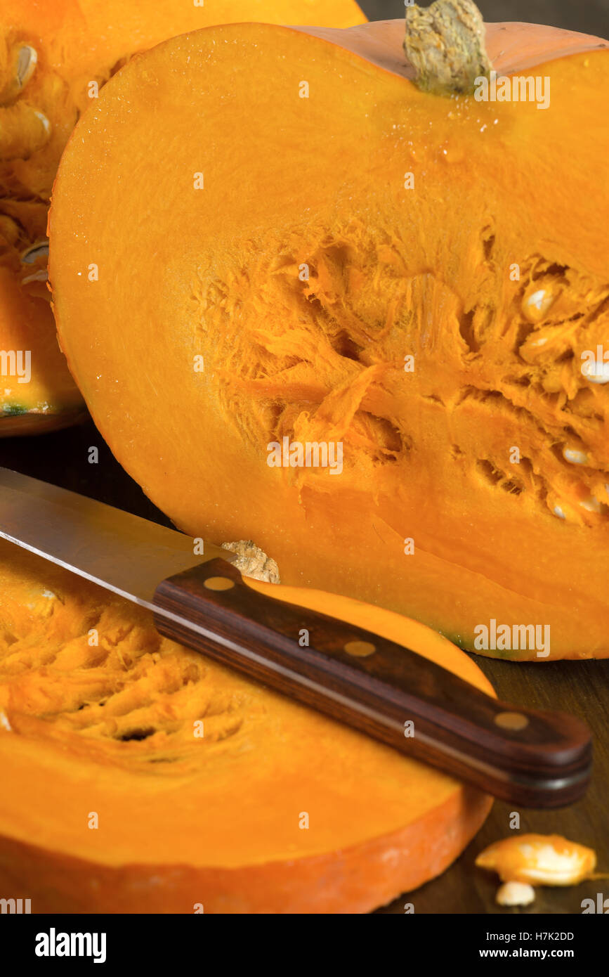 ripe pumpkin cut in half on a wooden background Stock Photo - Alamy