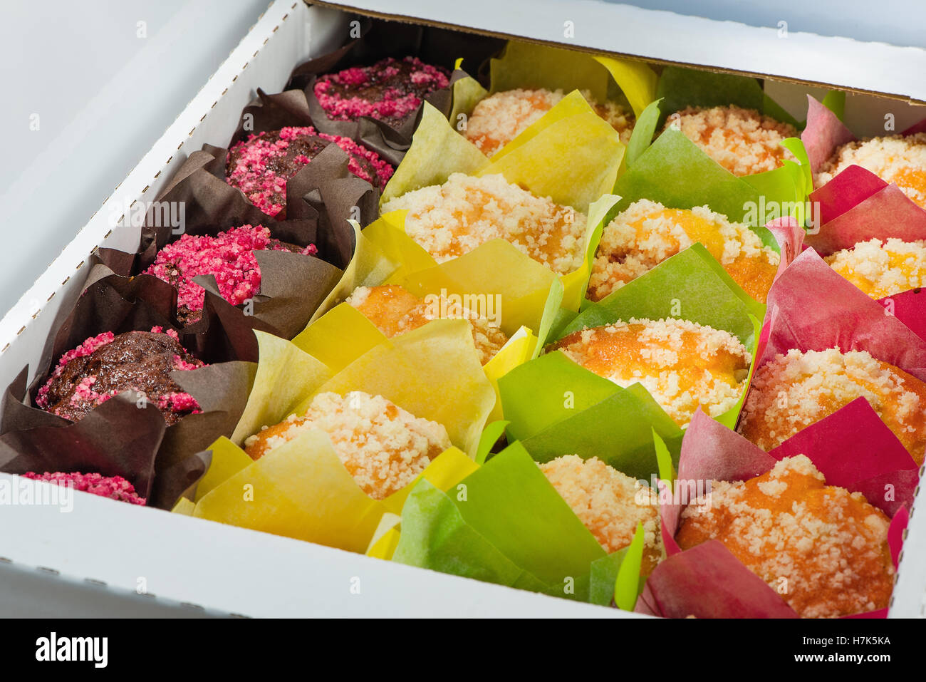 The muffins of different color packed into paper Stock Photo - Alamy