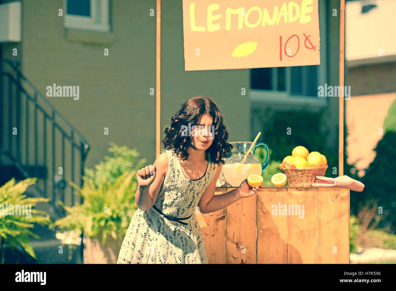 retro girl making funny face holding a lemon Stock Photo - Alamy