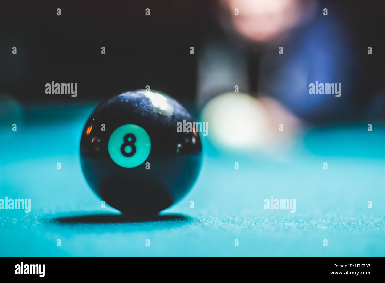 Photograph of an eight pool ball and blurred human silhouette Stock ...