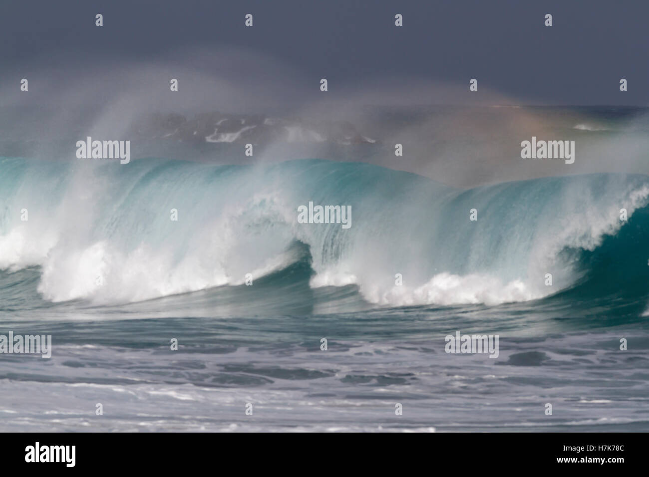 Rainbow colors light up the spray of a beautiful Ocean wave on the ...