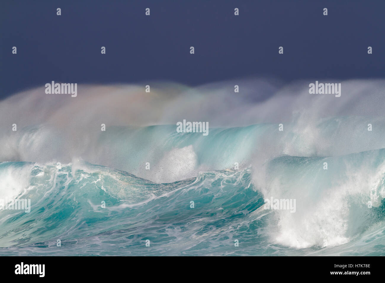 Rainbow colors light up the spray of a beautiful Ocean wave on the ...