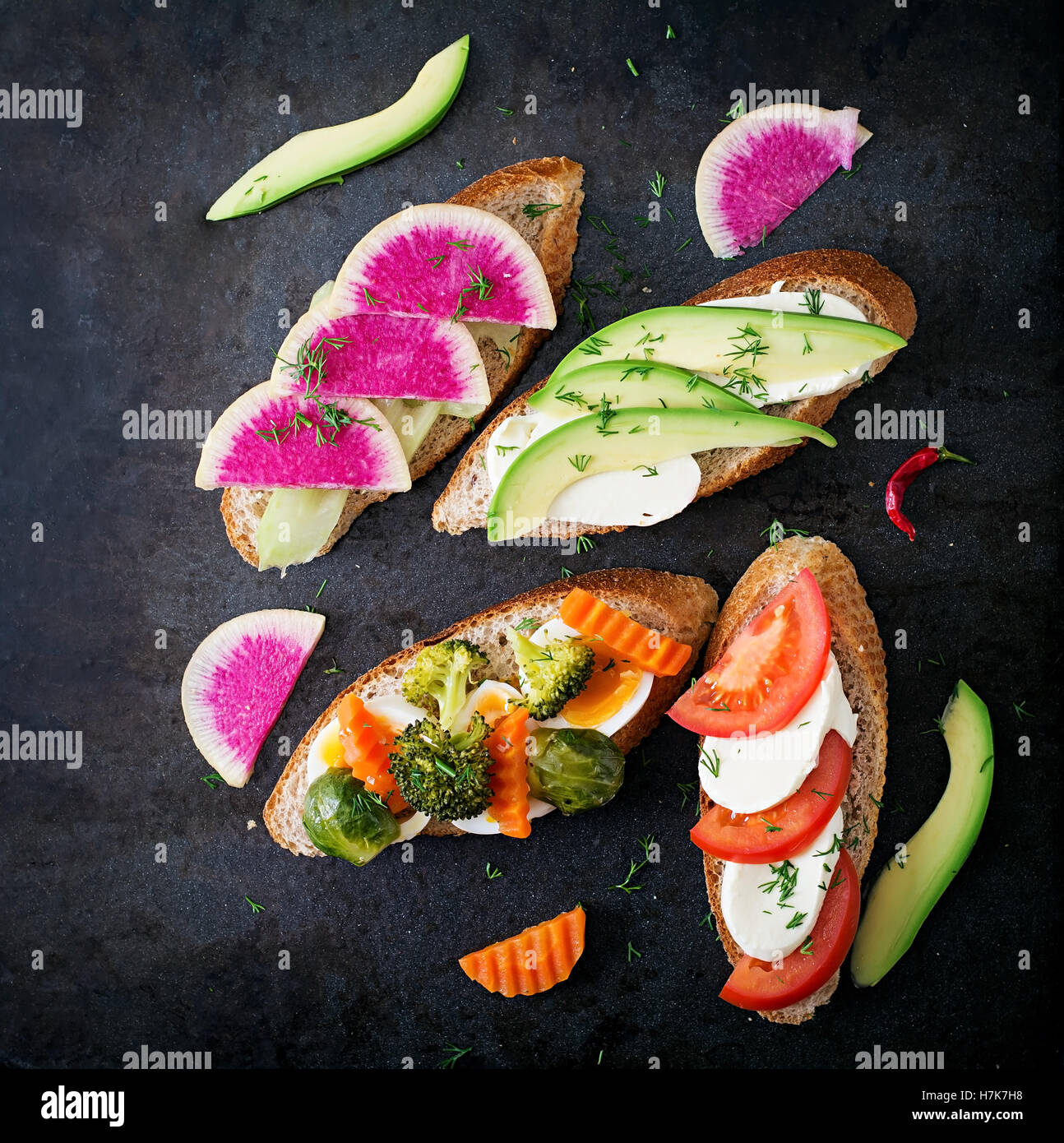 Variety of healthy sandwiches on a dark background in a rustic style ...