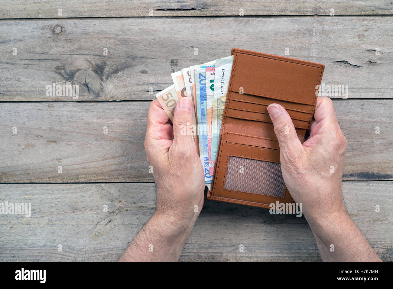 Man hand pulling bills from a wallet Stock Photo - Alamy