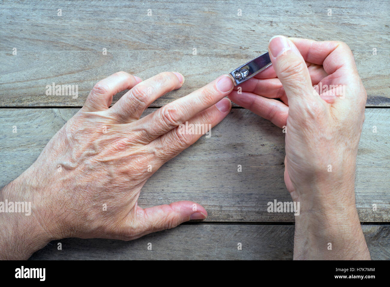 Male hands cutting their fingernails. Wooden background Stock Photo - Alamy