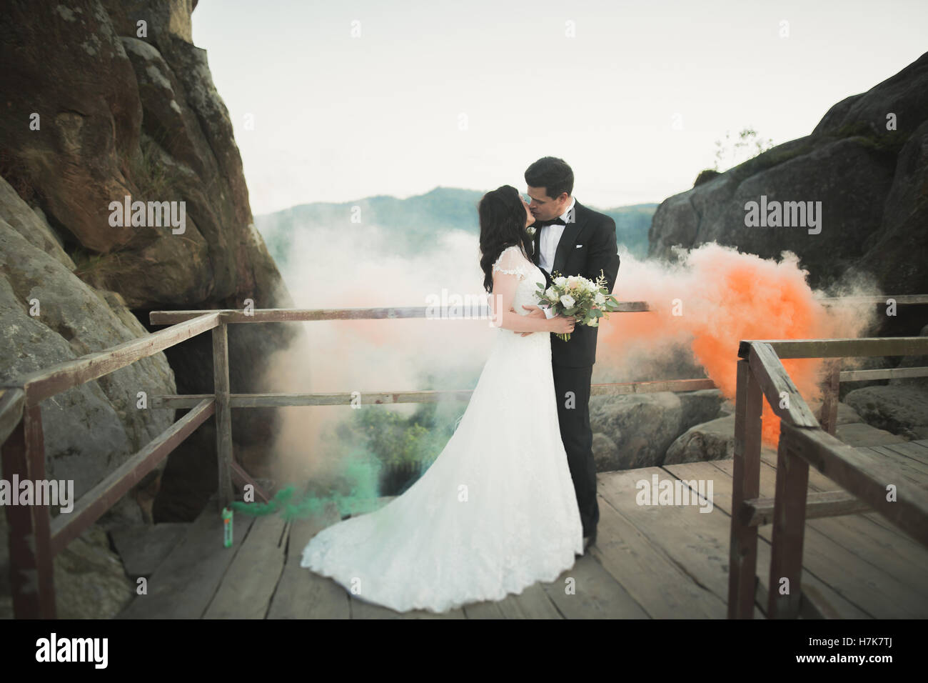 Wedding couple in love kissing and hugging near rocks on beautiful ...