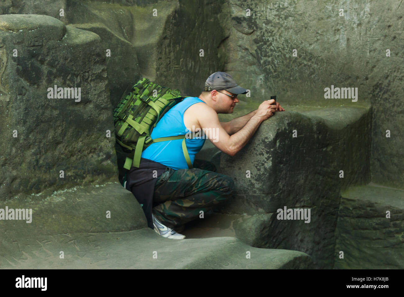 photographing man between rocks in a semi-sitting position Stock Photo ...