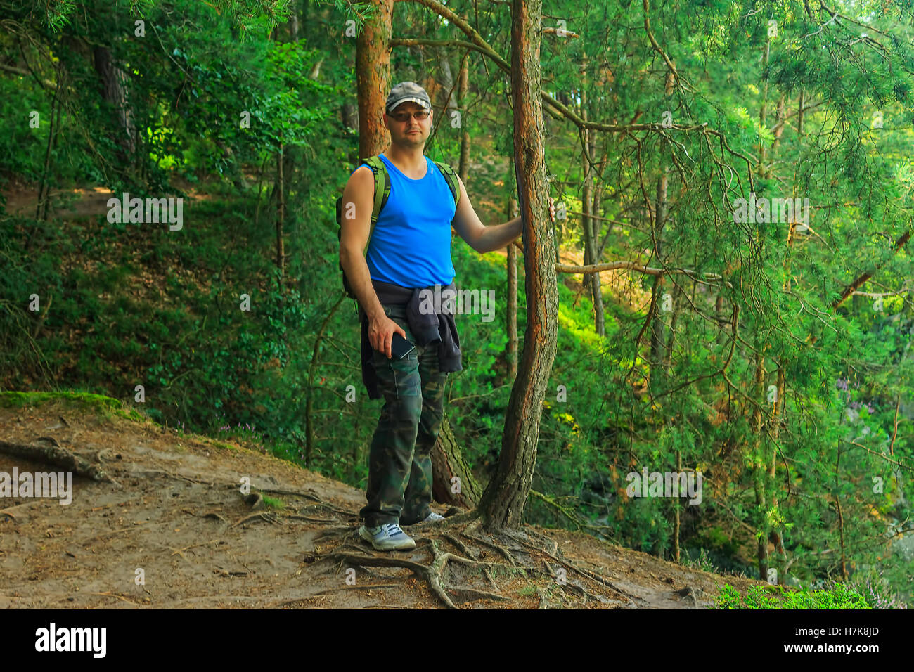 man posing in nature leaning on a tree Stock Photo - Alamy