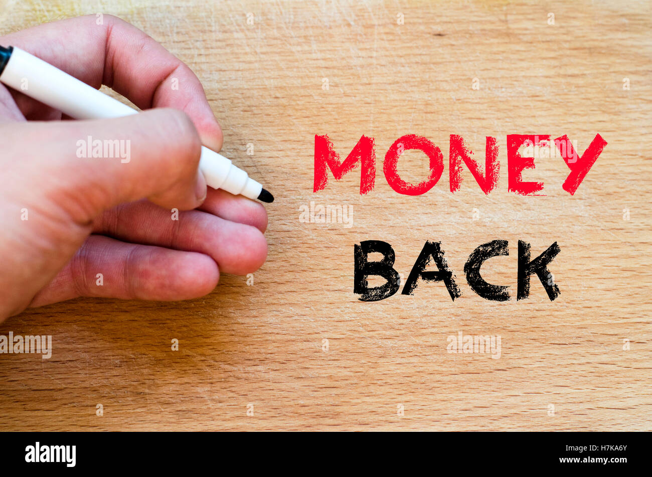Human hand over wooden background and money back text concept Stock ...