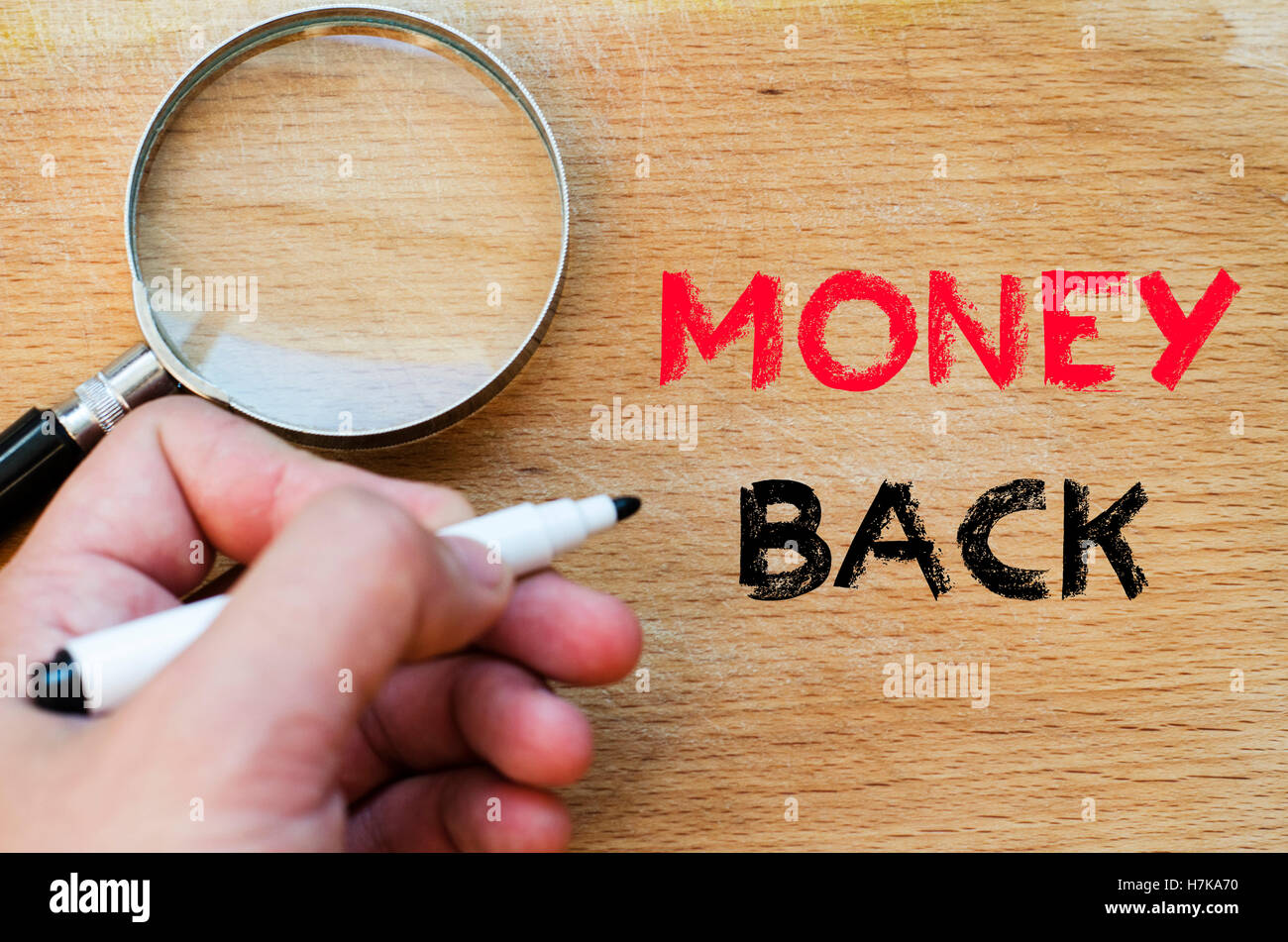 Human hand over wooden background and money back text concept Stock ...