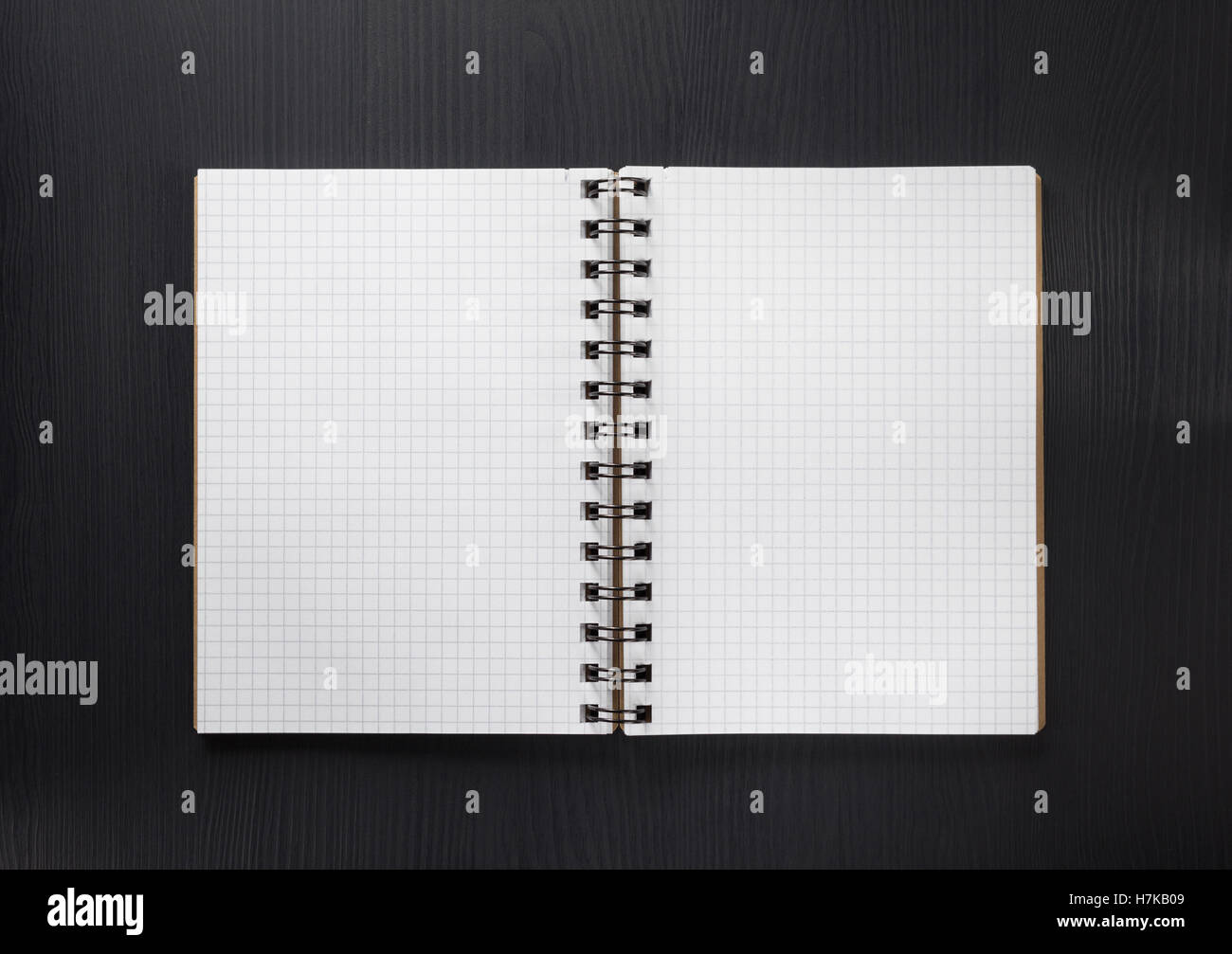 checked notebook on black wooden background Stock Photo - Alamy