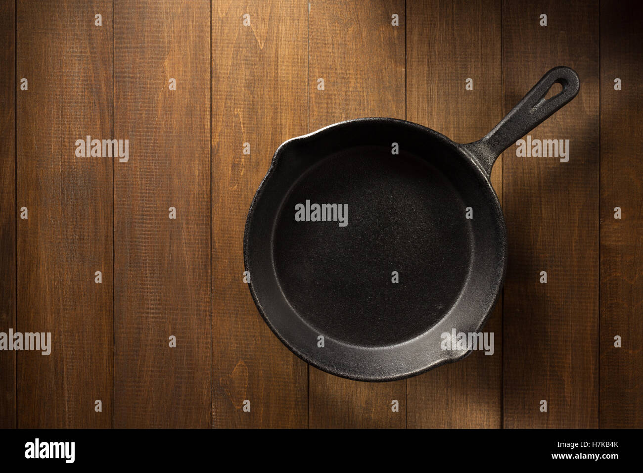 frying pan on wooden background texture Stock Photo - Alamy