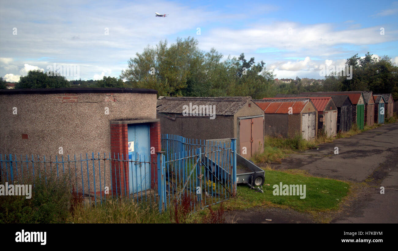 Dilapidated run down sheds still in use with airplane in sky Stock ...