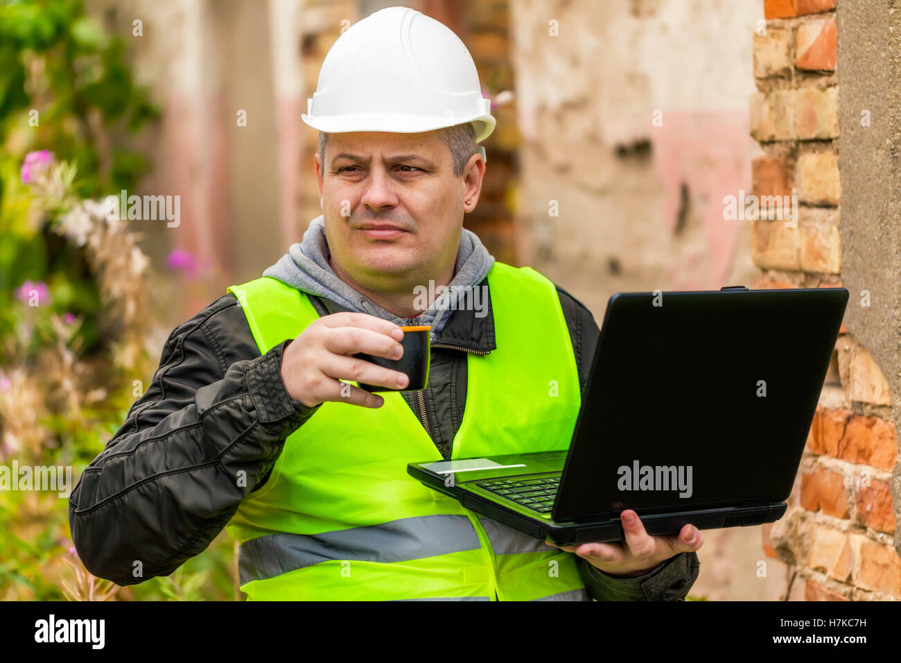Construction Engineer working with PC and drinking tea Stock Photo - Alamy