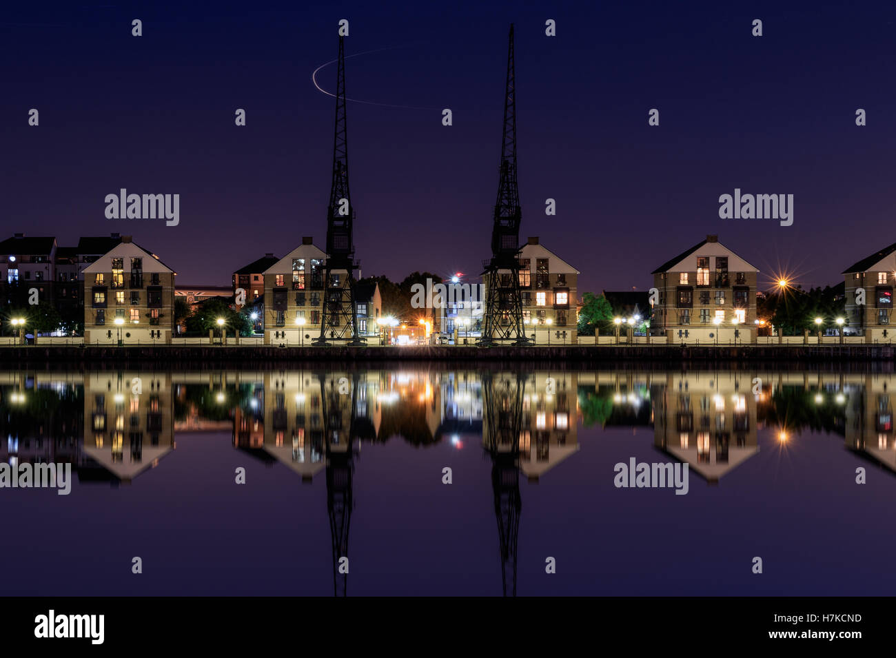 Royal Victoria Dock in London at twilight with dockside cranes and ...