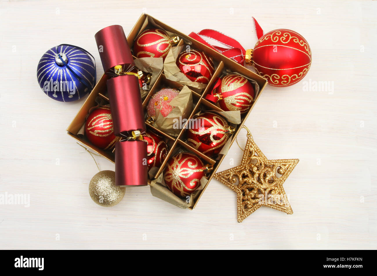 Christmas cracker, baubles and gold glitter star on white painted wood ...
